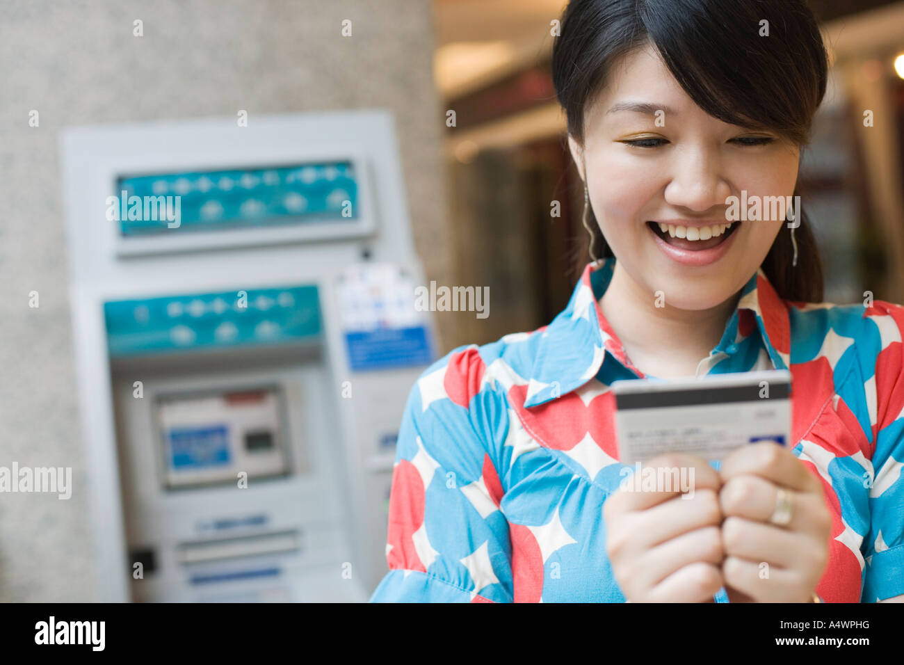 Young woman grinning at her credit card Stock Photo - Alamy