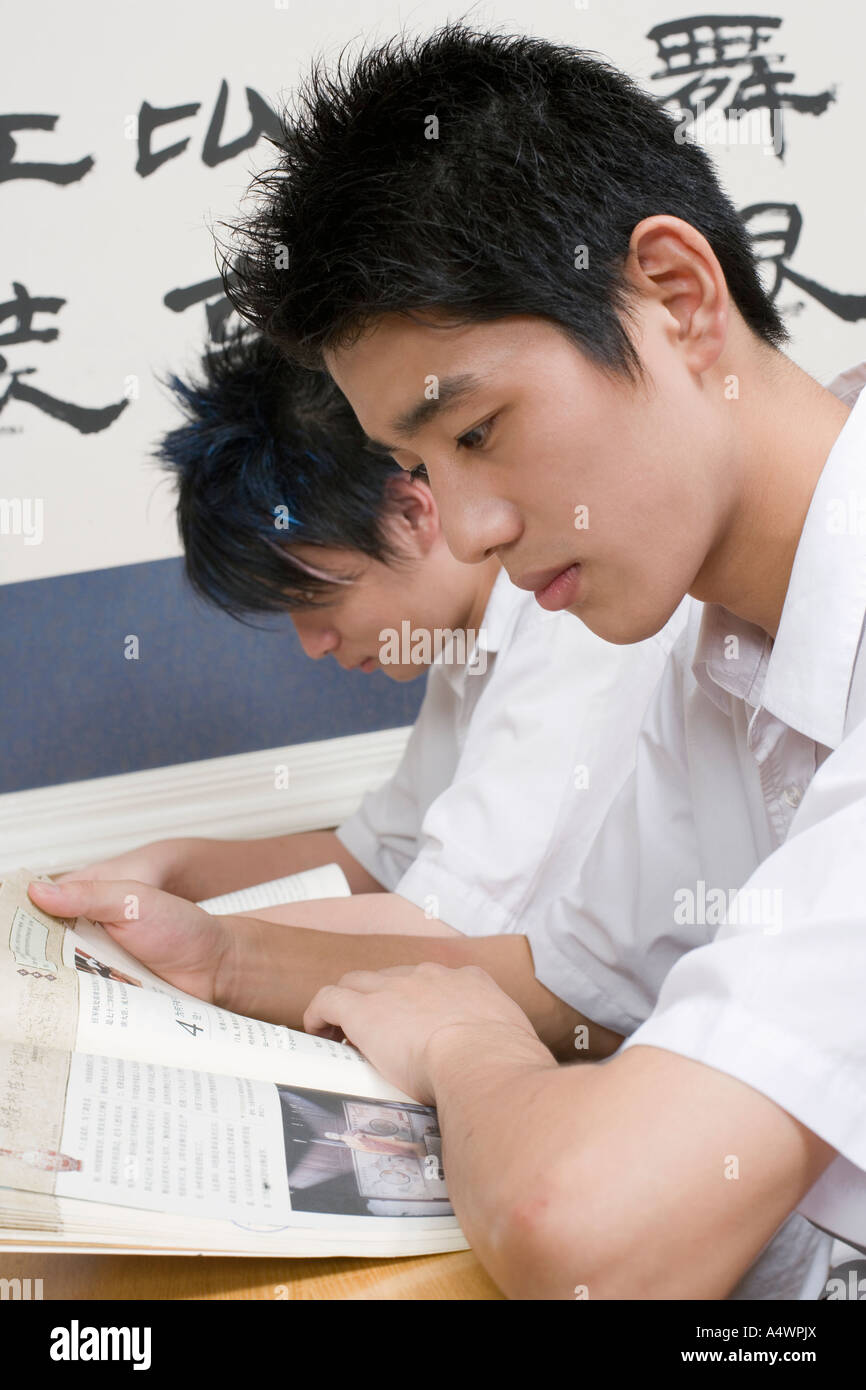 Male students reading at a table Stock Photo - Alamy