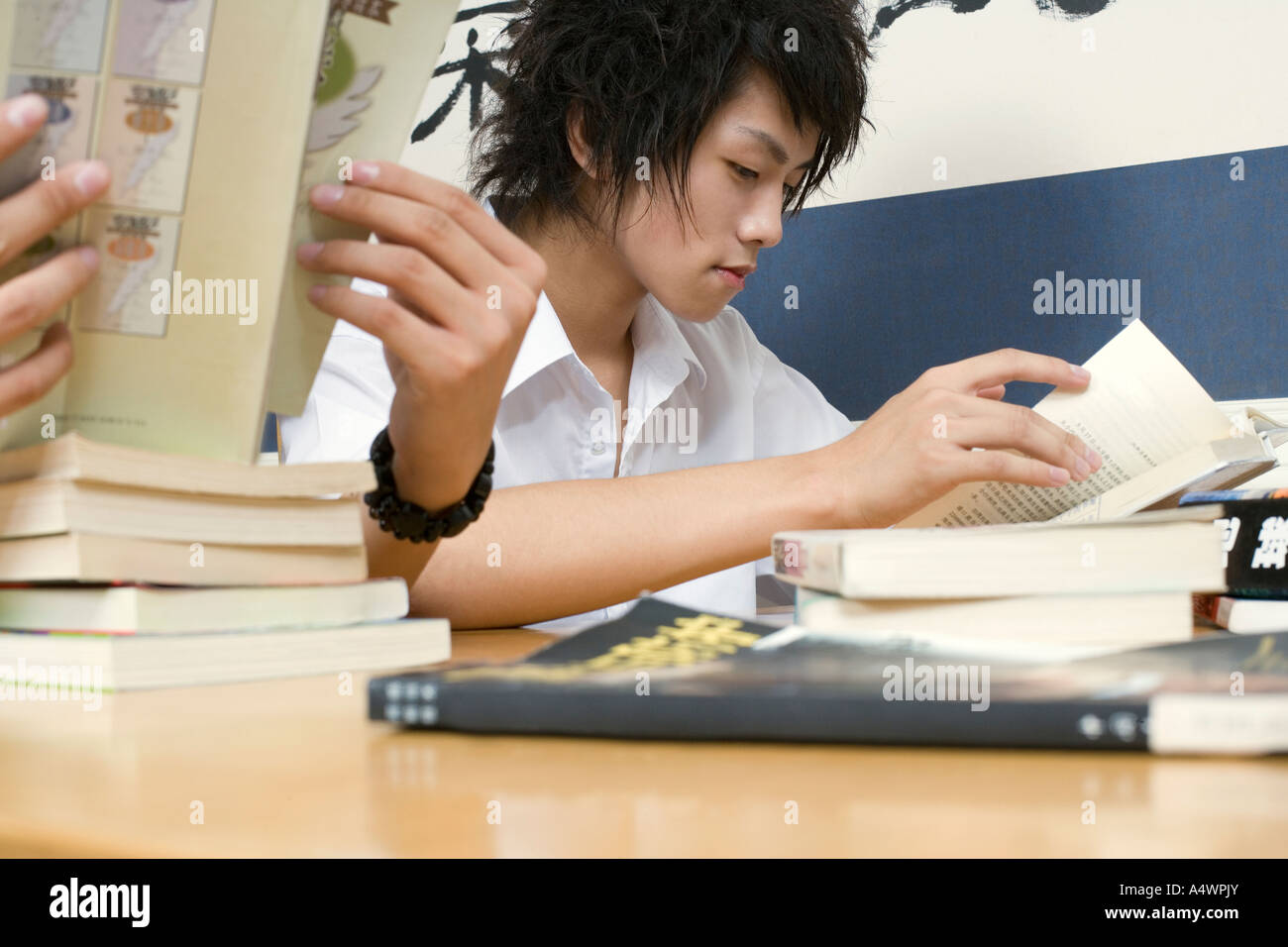 Male students reading at a table Stock Photo - Alamy
