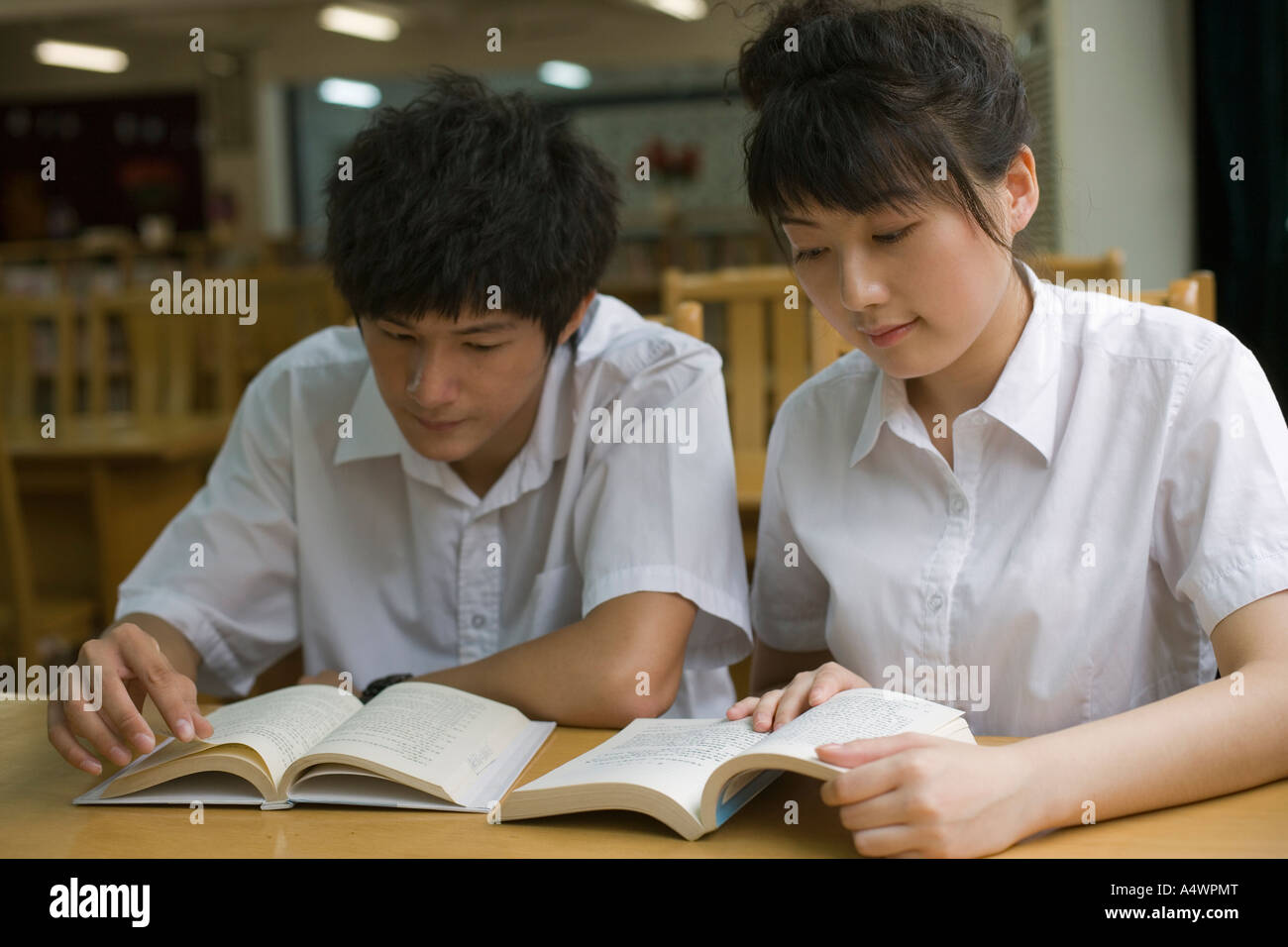 Students reading at a table Stock Photo - Alamy