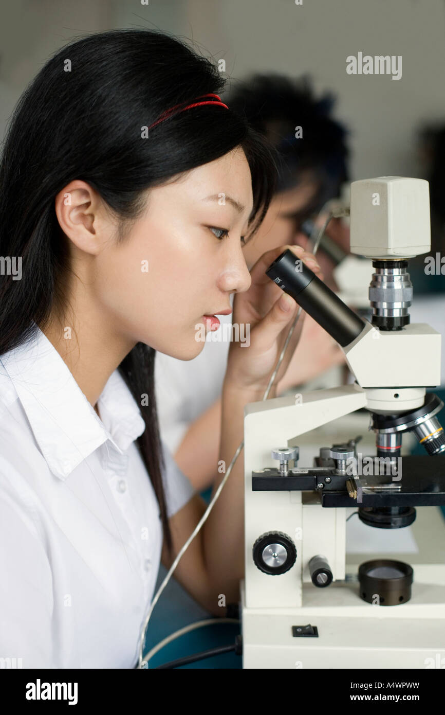 Female student using a microscope Stock Photo - Alamy
