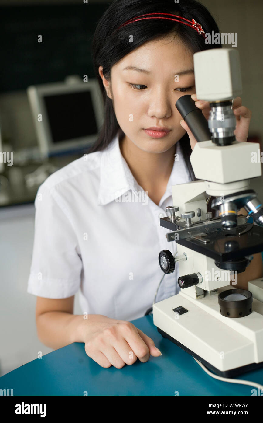 Female student using a microscope Stock Photo - Alamy