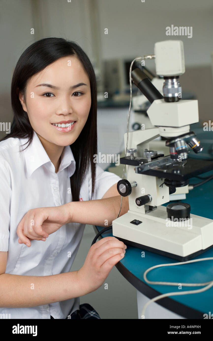 Female student using a microscope Stock Photo - Alamy