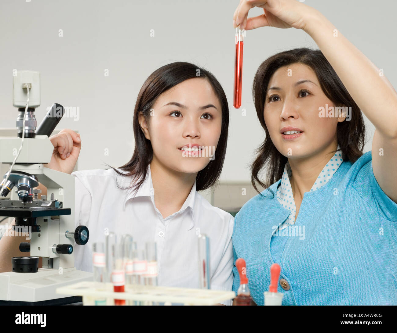 Teacher and student examining the contents of a test tube Stock Photo ...