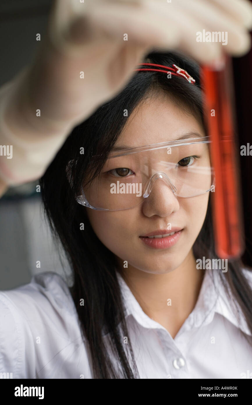 Female student examining the contents of a test tube Stock Photo - Alamy