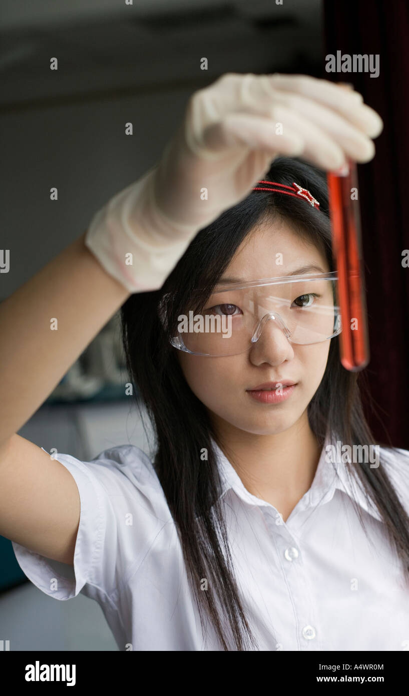 Female student examining the contents of a test tube Stock Photo - Alamy