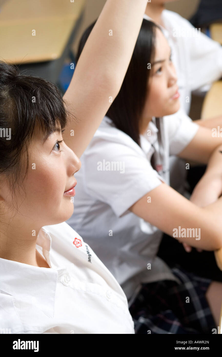 Female student raising her hand in class Stock Photo - Alamy