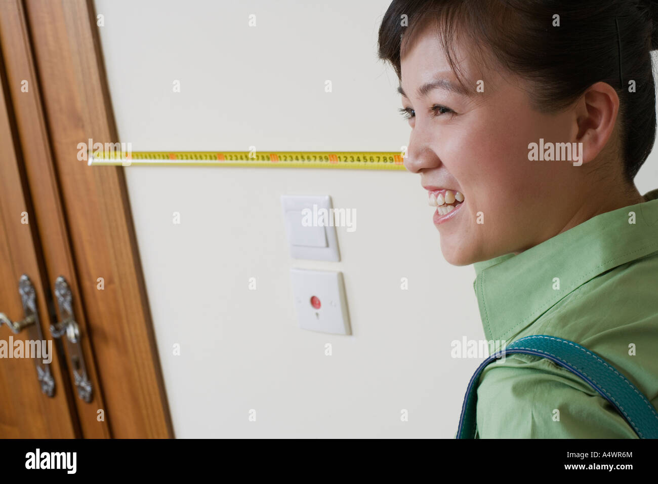 Young woman measuring wall Stock Photo - Alamy