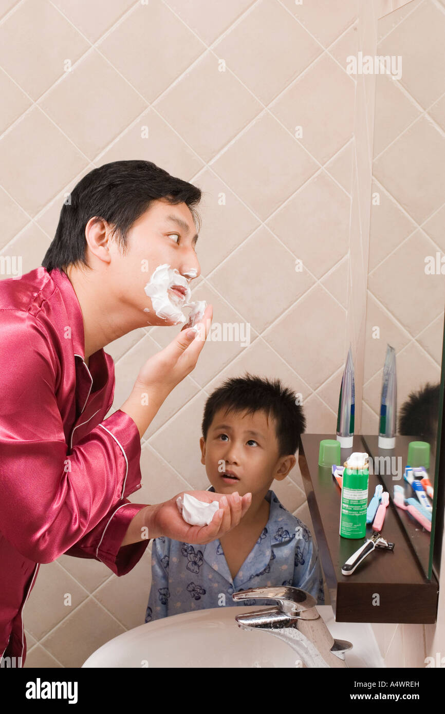 Father shaving as his son watches Stock Photo - Alamy