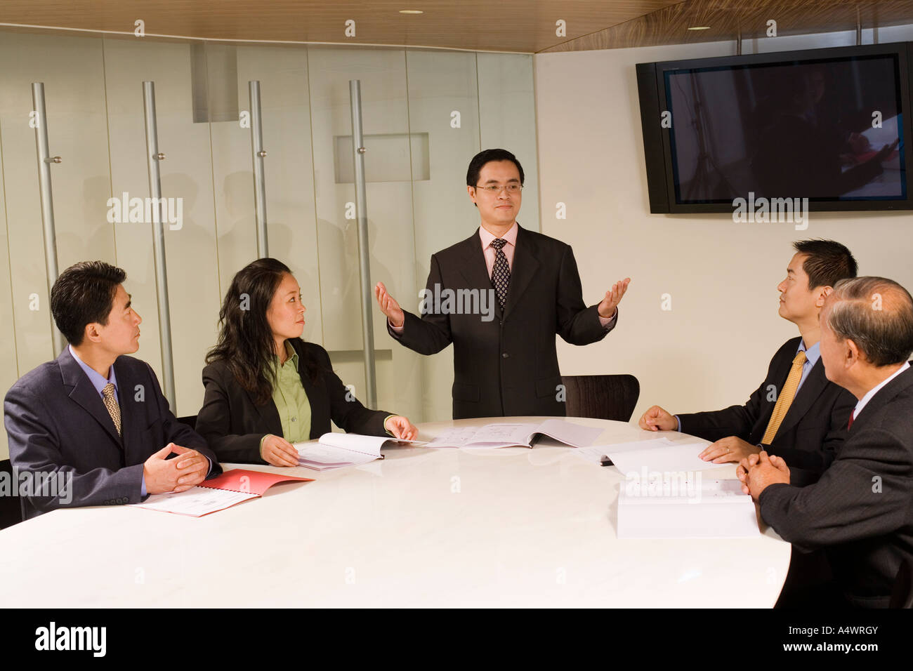 Businessman standing up in a meeting Stock Photo - Alamy