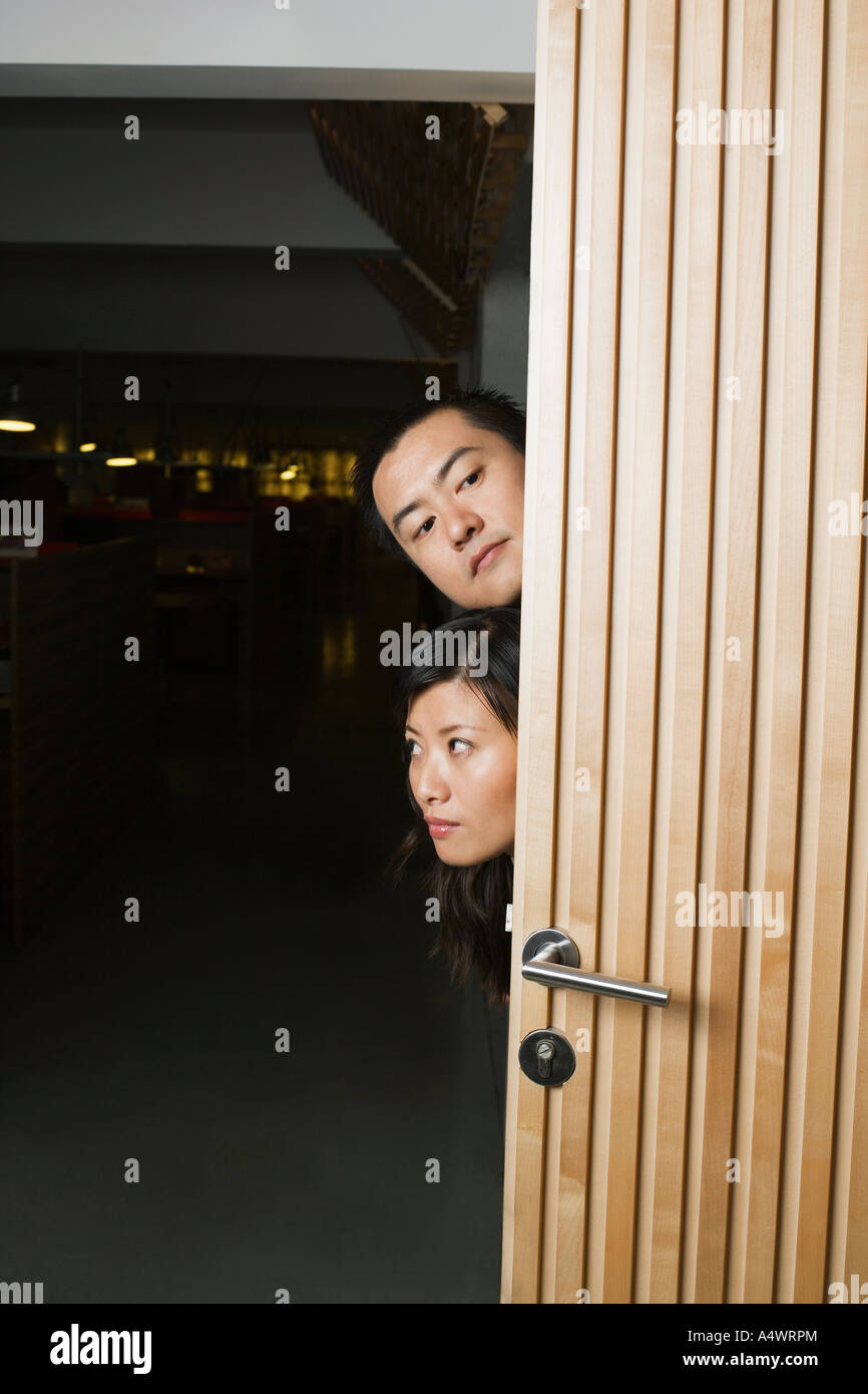 Woman peeking around corner hi-res stock photography and images - Alamy