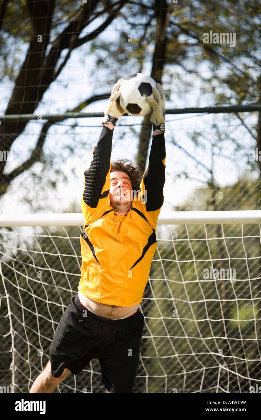Male soccer goalie jumping for ball Stock Photo - Alamy