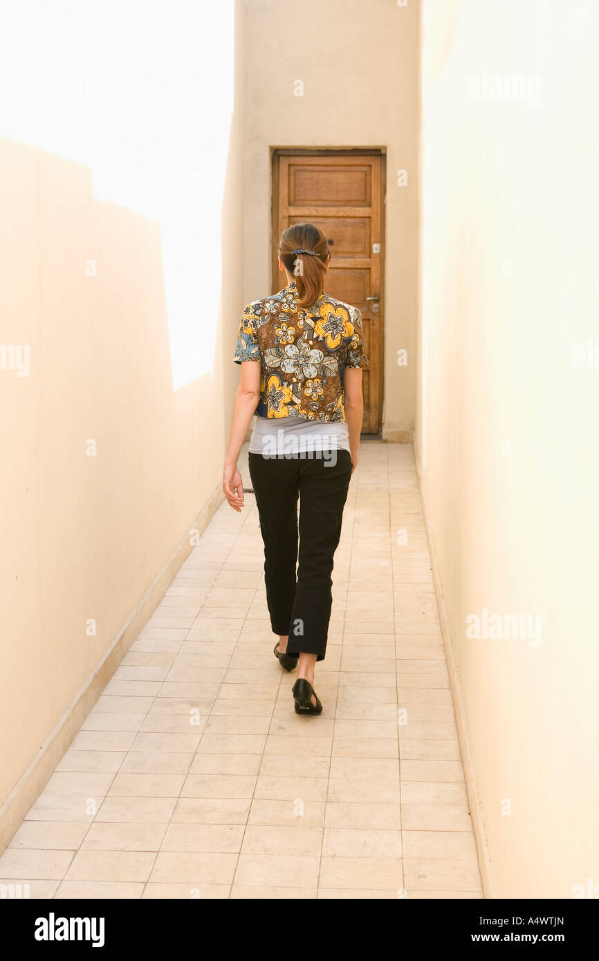 Woman walking down corridor Stock Photo - Alamy
