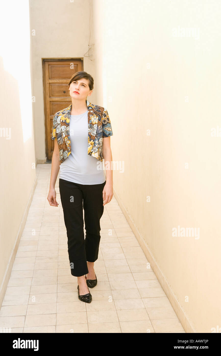 Woman walking down corridor Stock Photo - Alamy