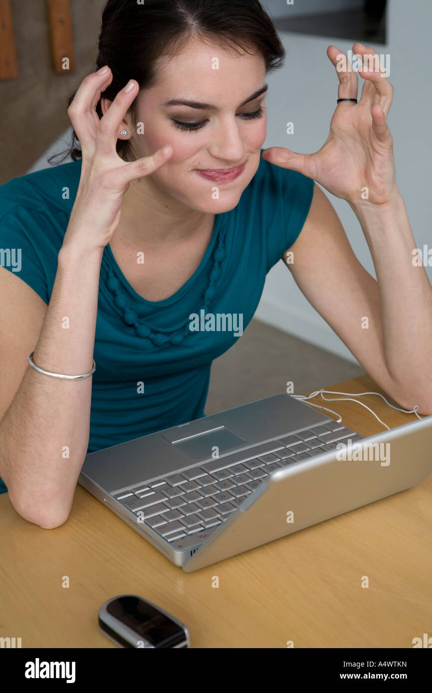 Frustrated woman using a laptop at table Stock Photo - Alamy