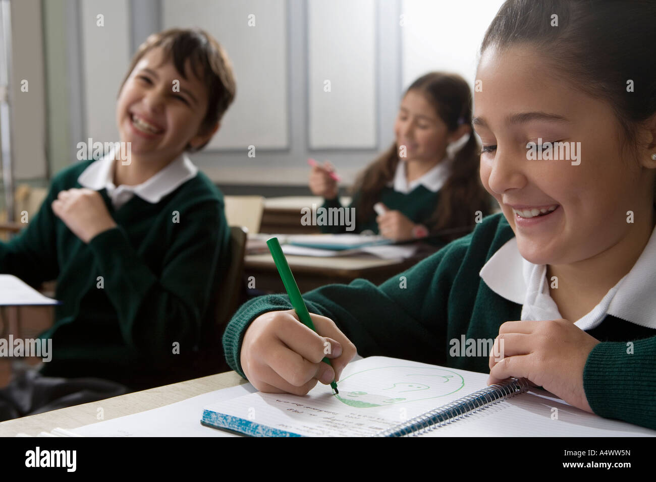 Laughing young student taking notes in class Stock Photo - Alamy