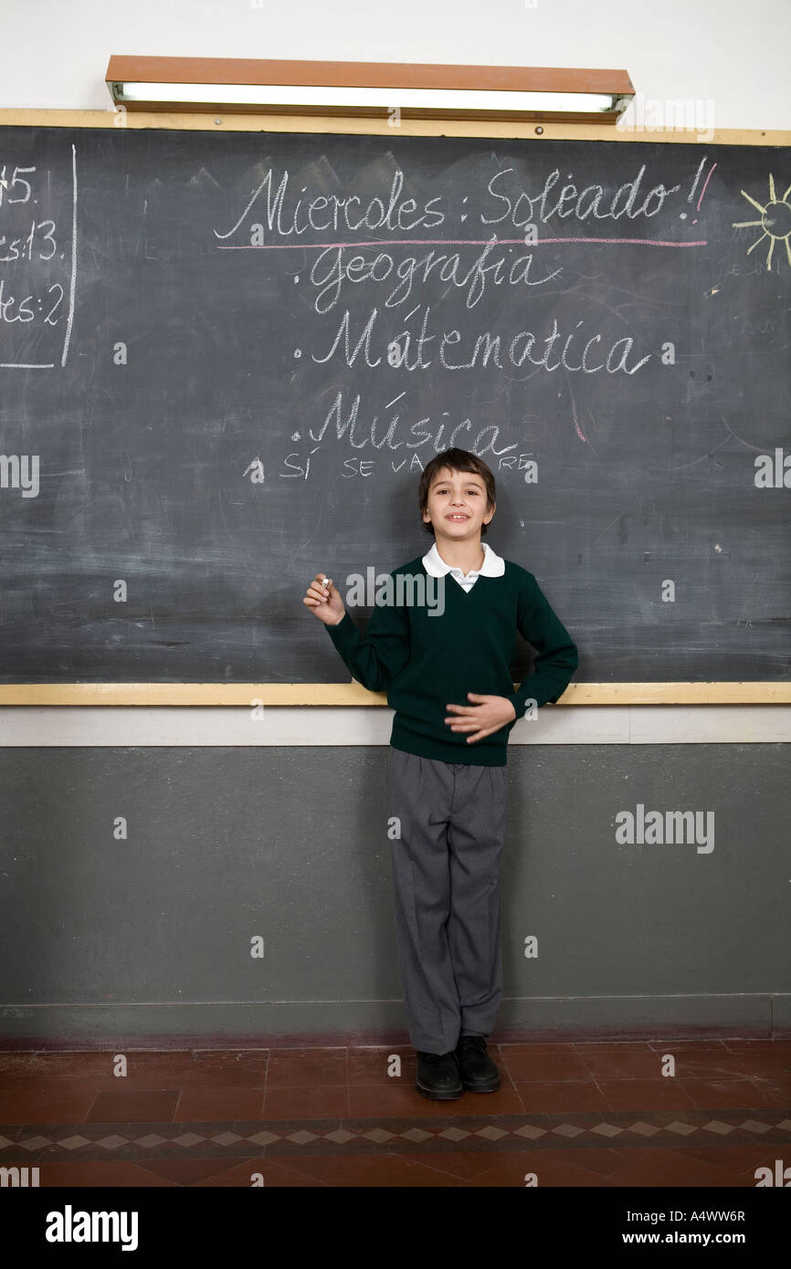 Young student standing in front of chalkboard Stock Photo - Alamy