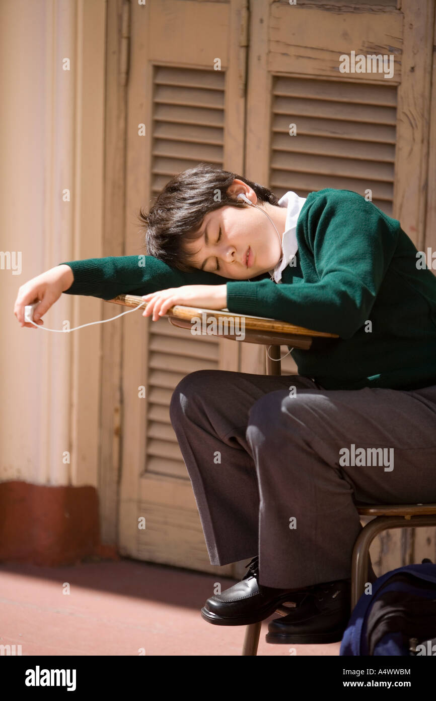 Student listening to his mp3 player while sleeping at his desk Stock ...