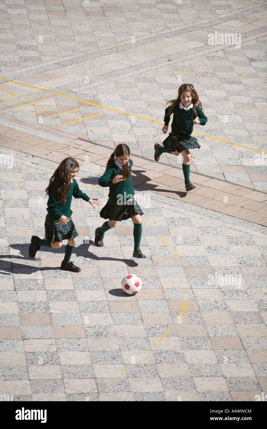 Young students playing soccer in courtyard Stock Photo - Alamy