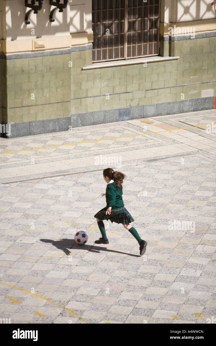Young girl playing soccer in courtyard Stock Photo - Alamy