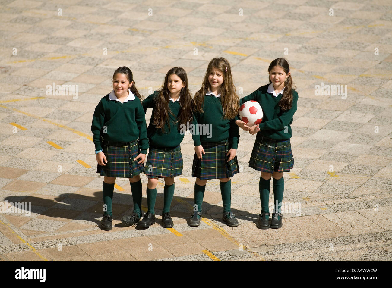 Young students holding soccer ball in courtyard Stock Photo - Alamy