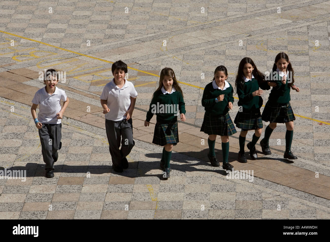 Young students running around courtyard Stock Photo - Alamy