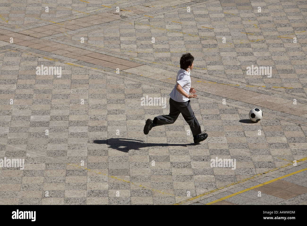 Young student playing soccer in courtyard Stock Photo - Alamy