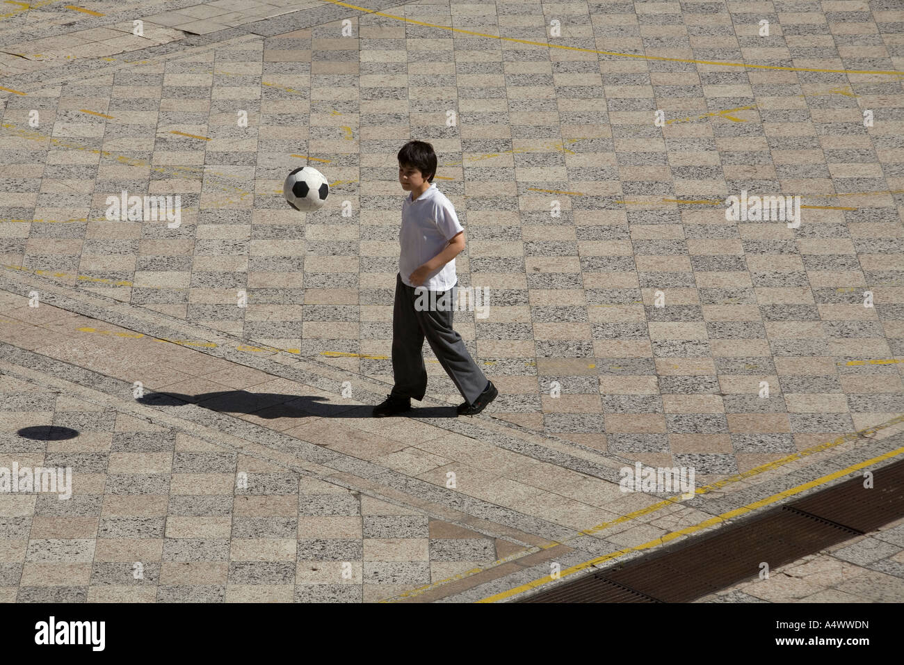 Young student playing soccer in courtyard Stock Photo - Alamy