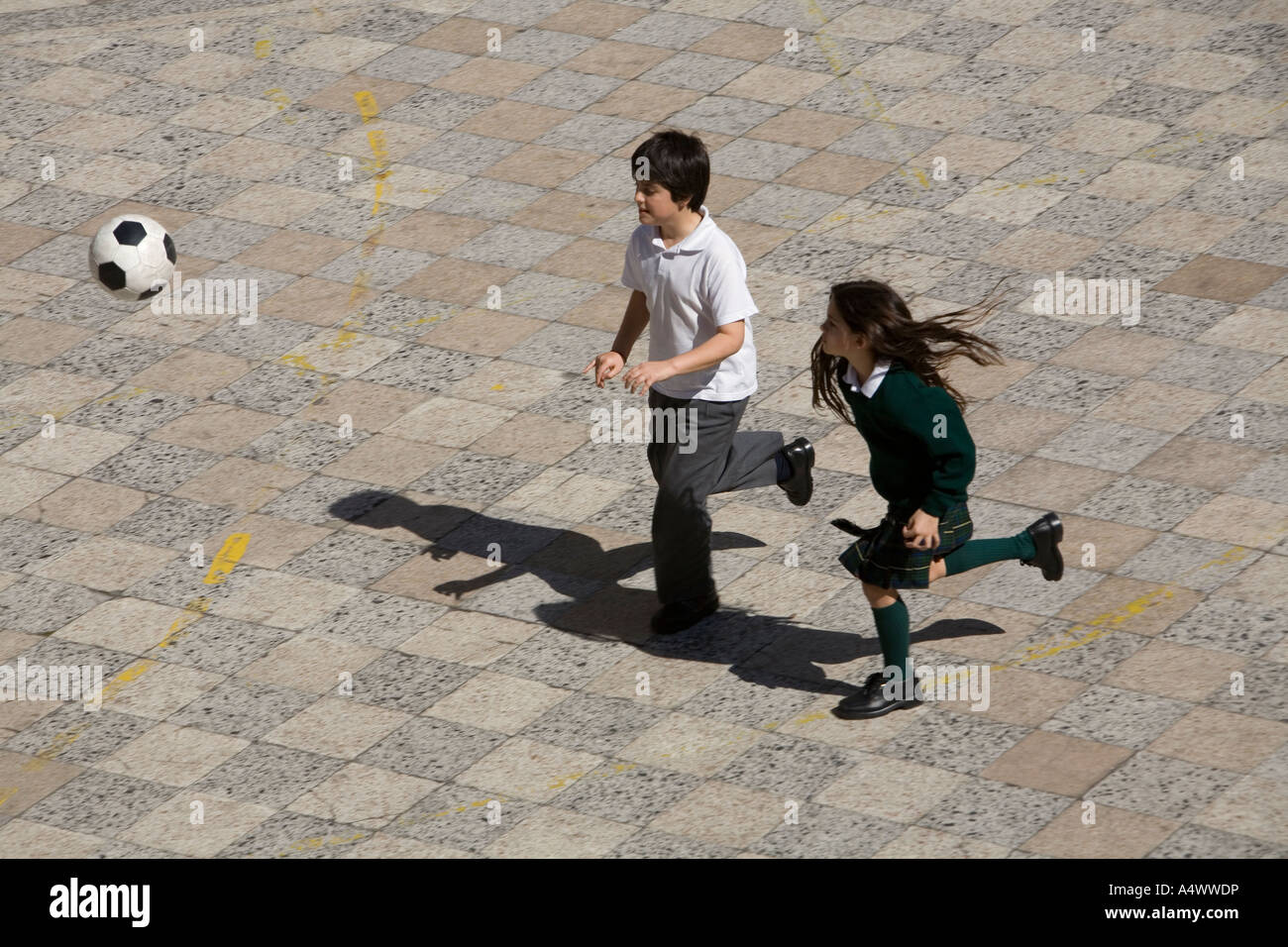 Young students playing soccer in courtyard Stock Photo - Alamy