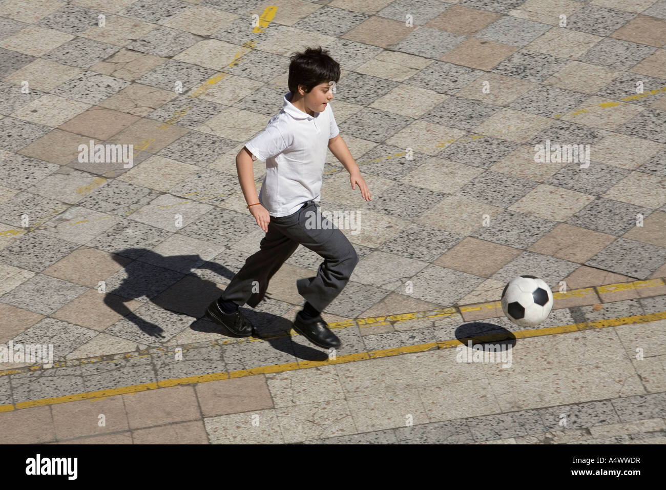 Young students playing soccer in courtyard Stock Photo - Alamy