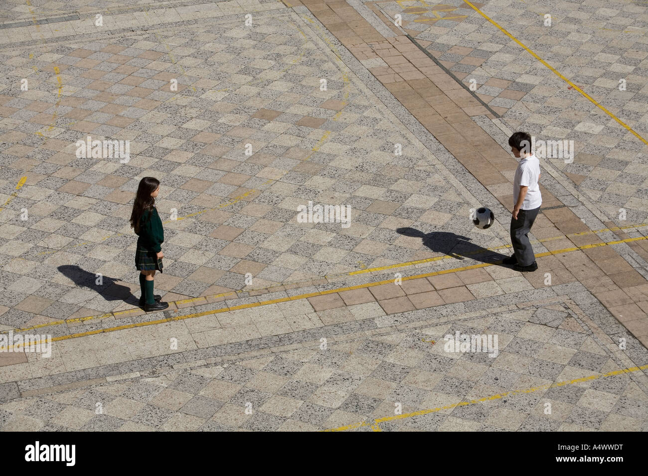 Young students playing soccer in courtyard Stock Photo - Alamy