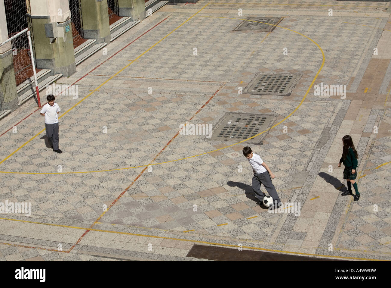 Young students playing soccer in courtyard Stock Photo - Alamy