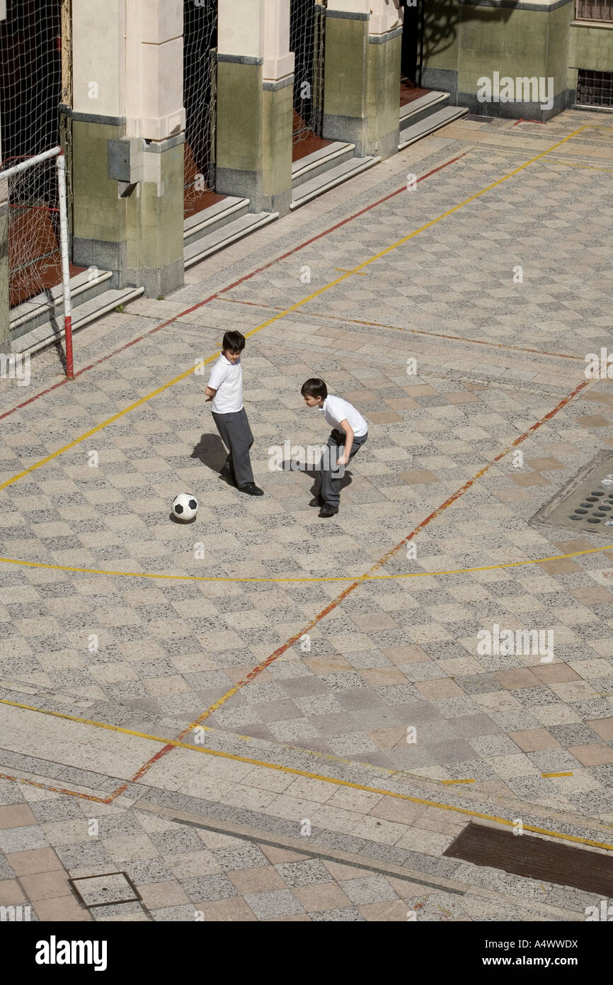 Young students playing soccer in courtyard Stock Photo - Alamy