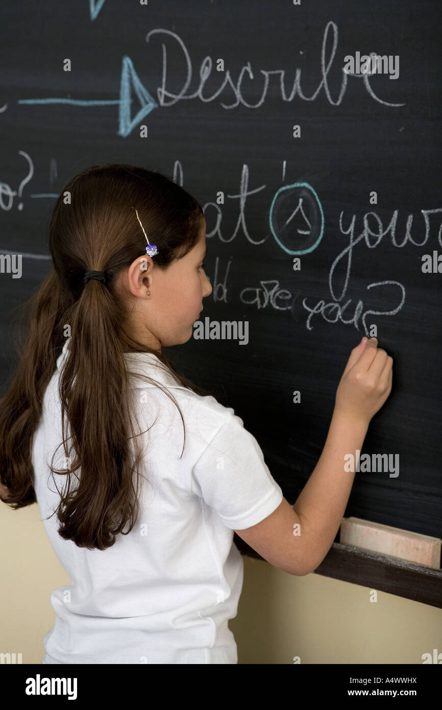 Young student writing on the blackboard in class Stock Photo - Alamy