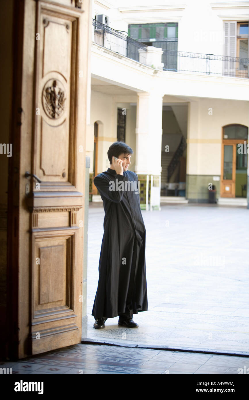 Robed priest talking on his cell phone outdoors Stock Photo - Alamy