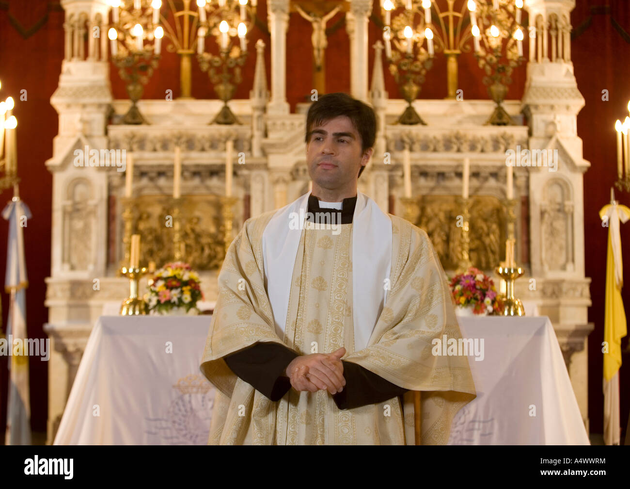 Robed priest standing at the altar of a church Stock Photo - Alamy