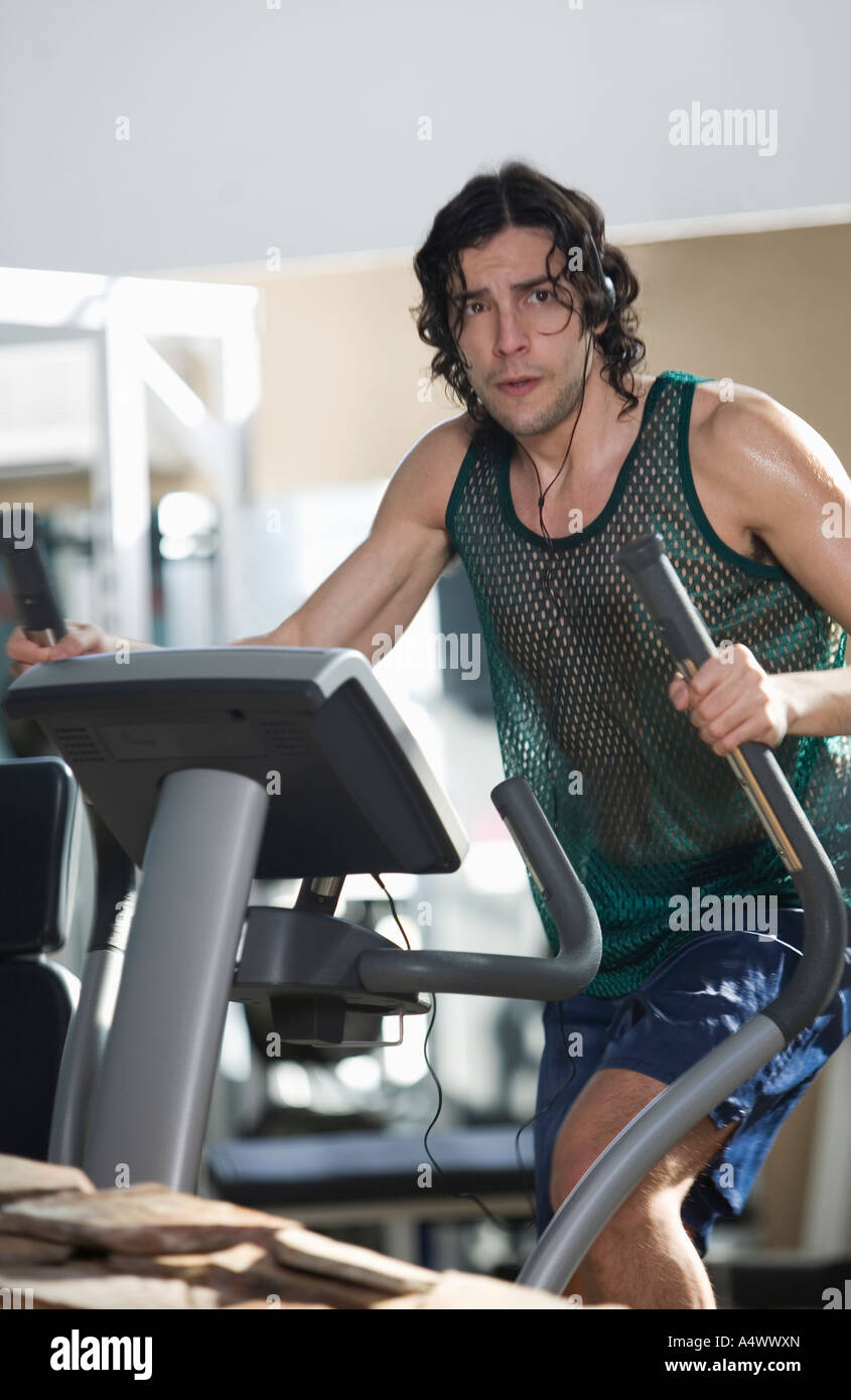 Man using the elliptical machine at a gym Stock Photo - Alamy