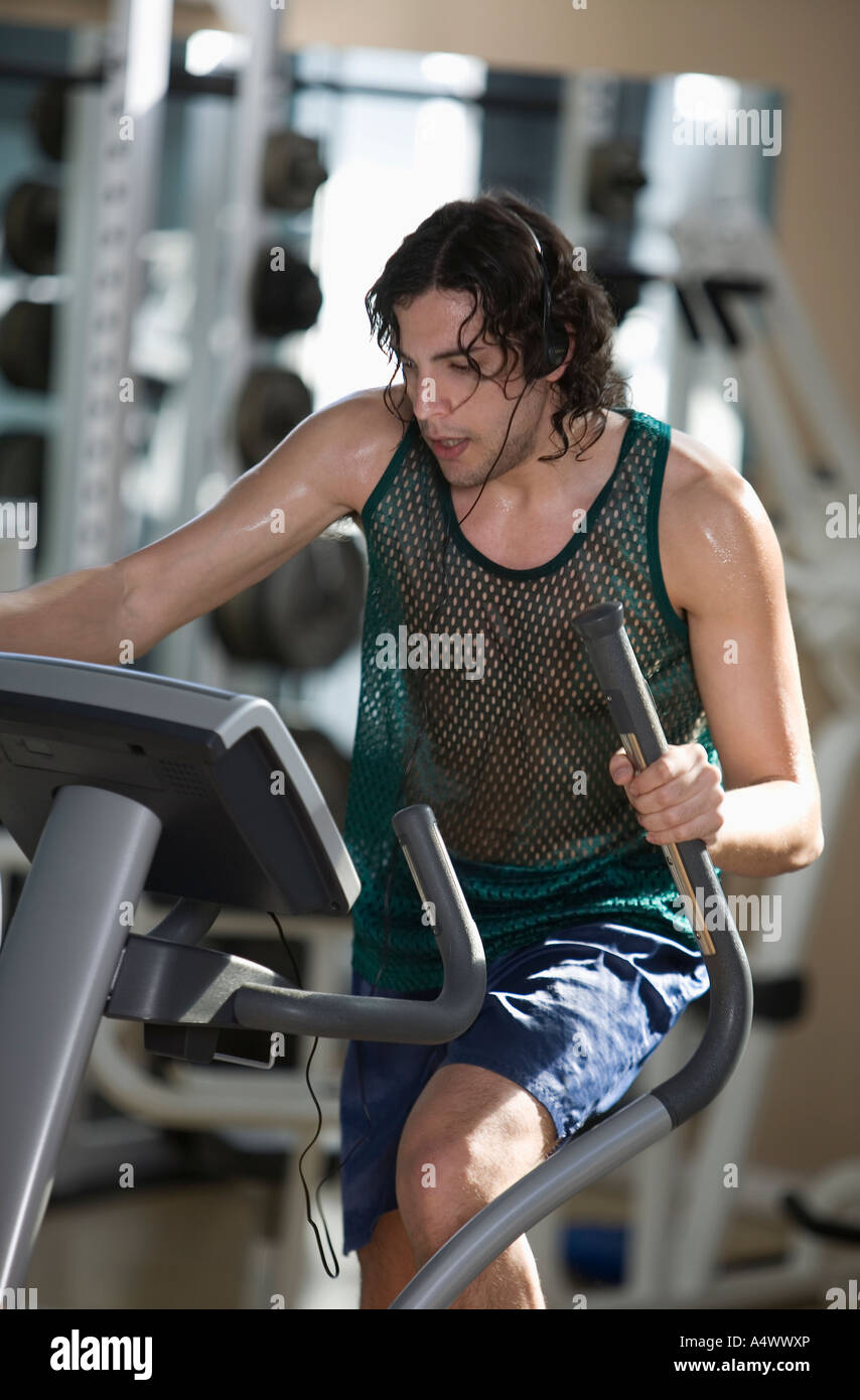 Man using the elliptical machine at a gym Stock Photo - Alamy