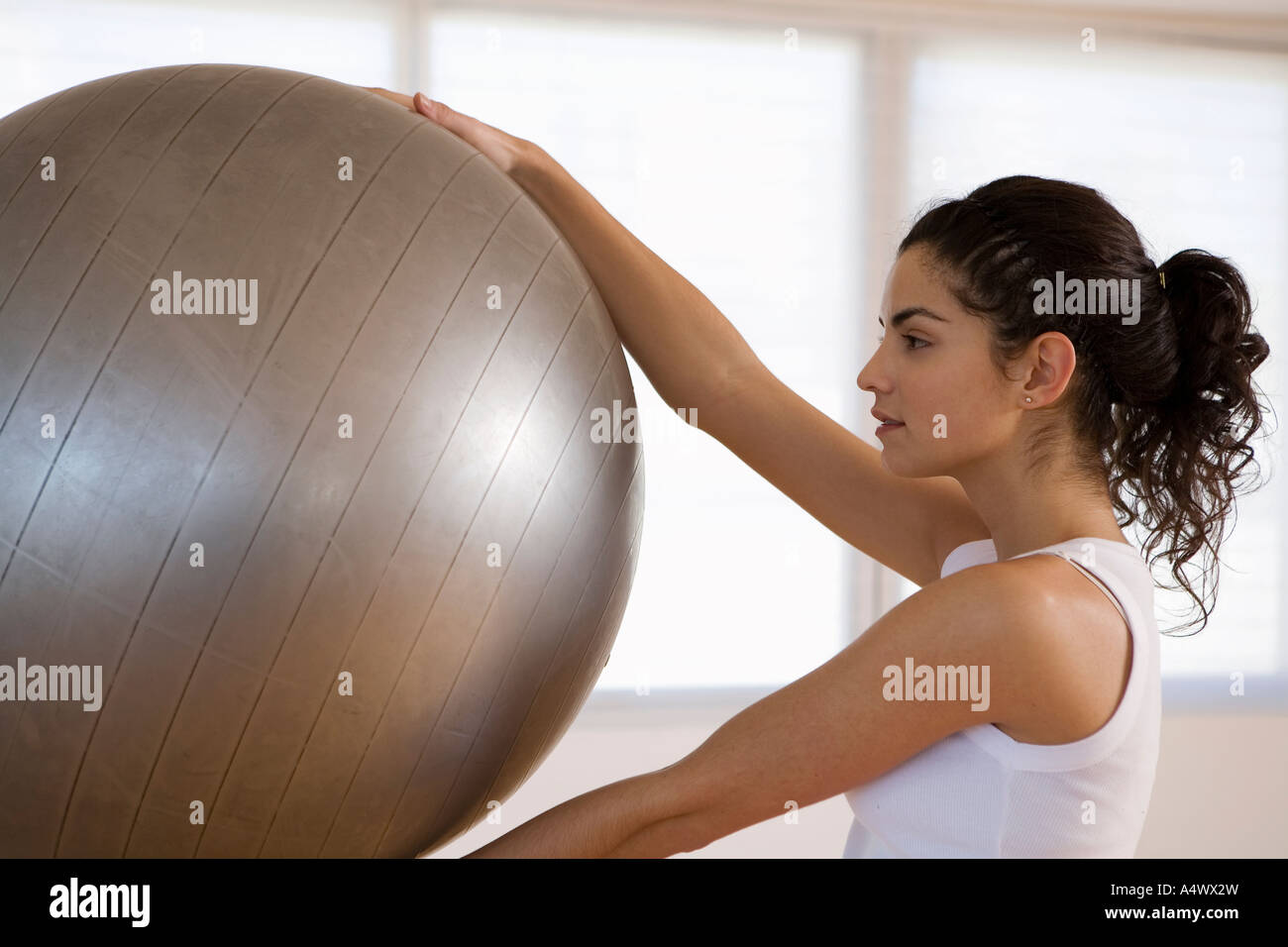 Woman lifting exercise ball Stock Photo - Alamy