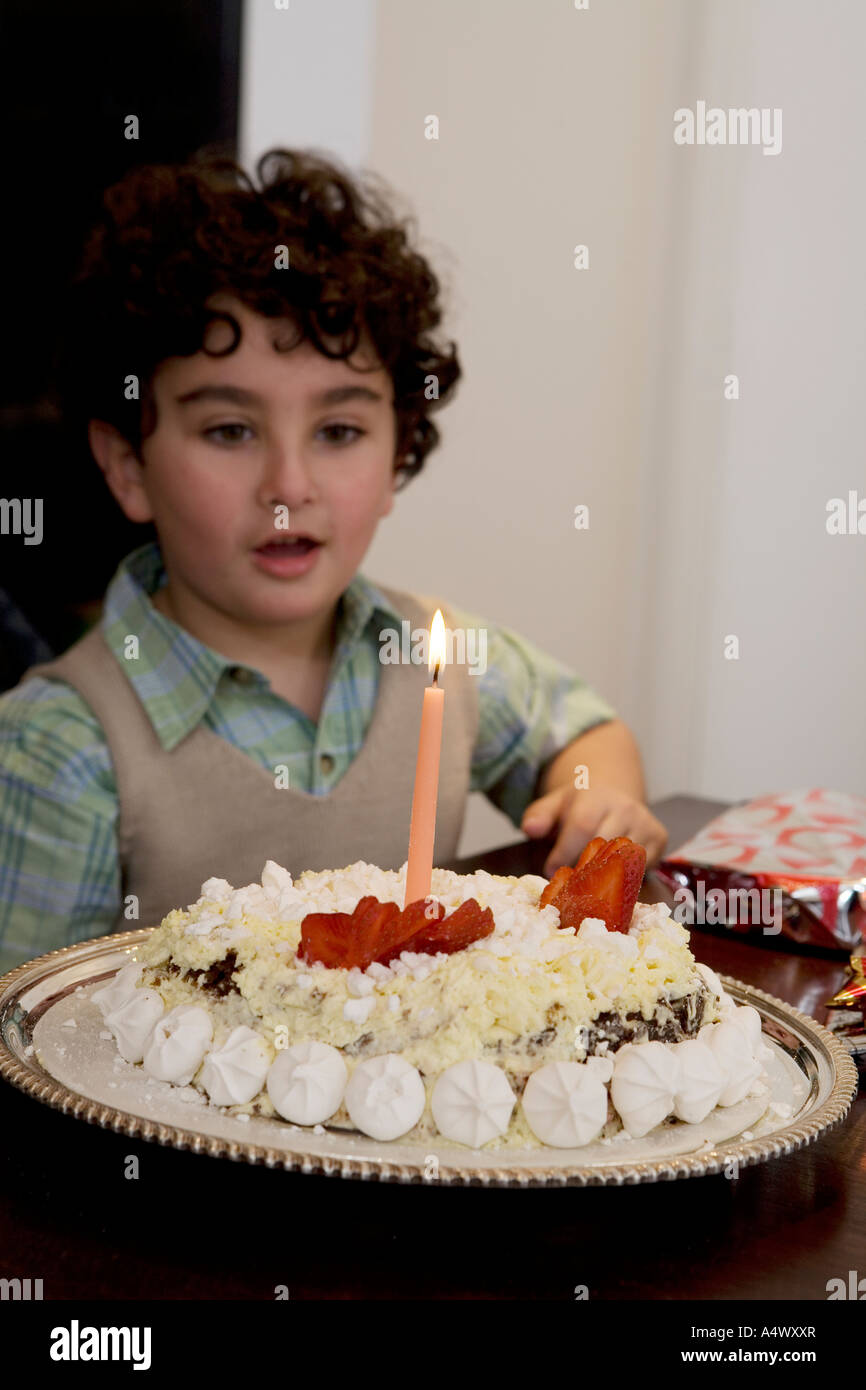 Young boy blowing out candle on birthday cake Stock Photo - Alamy