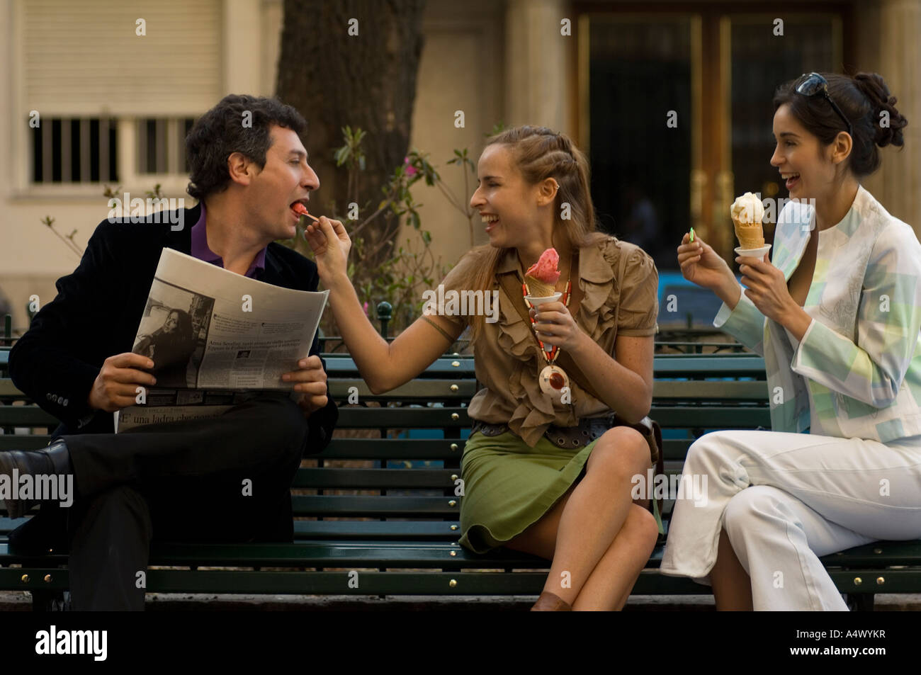 Women sharing ice cream in a park Stock Photo - Alamy