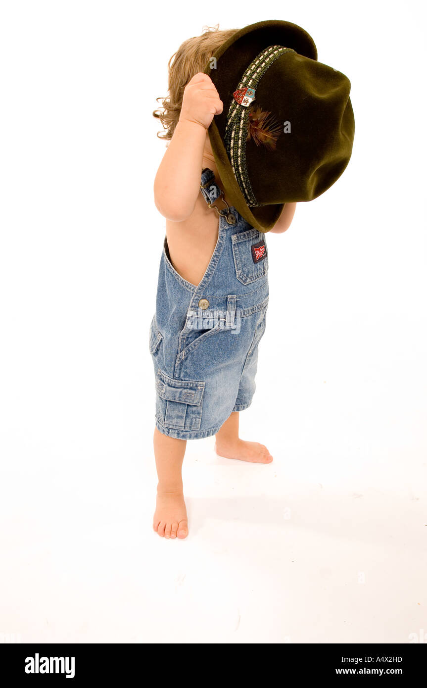 LITTLE BOY IN OVERALL WITH HAT OVER FACE Stock Photo - Alamy