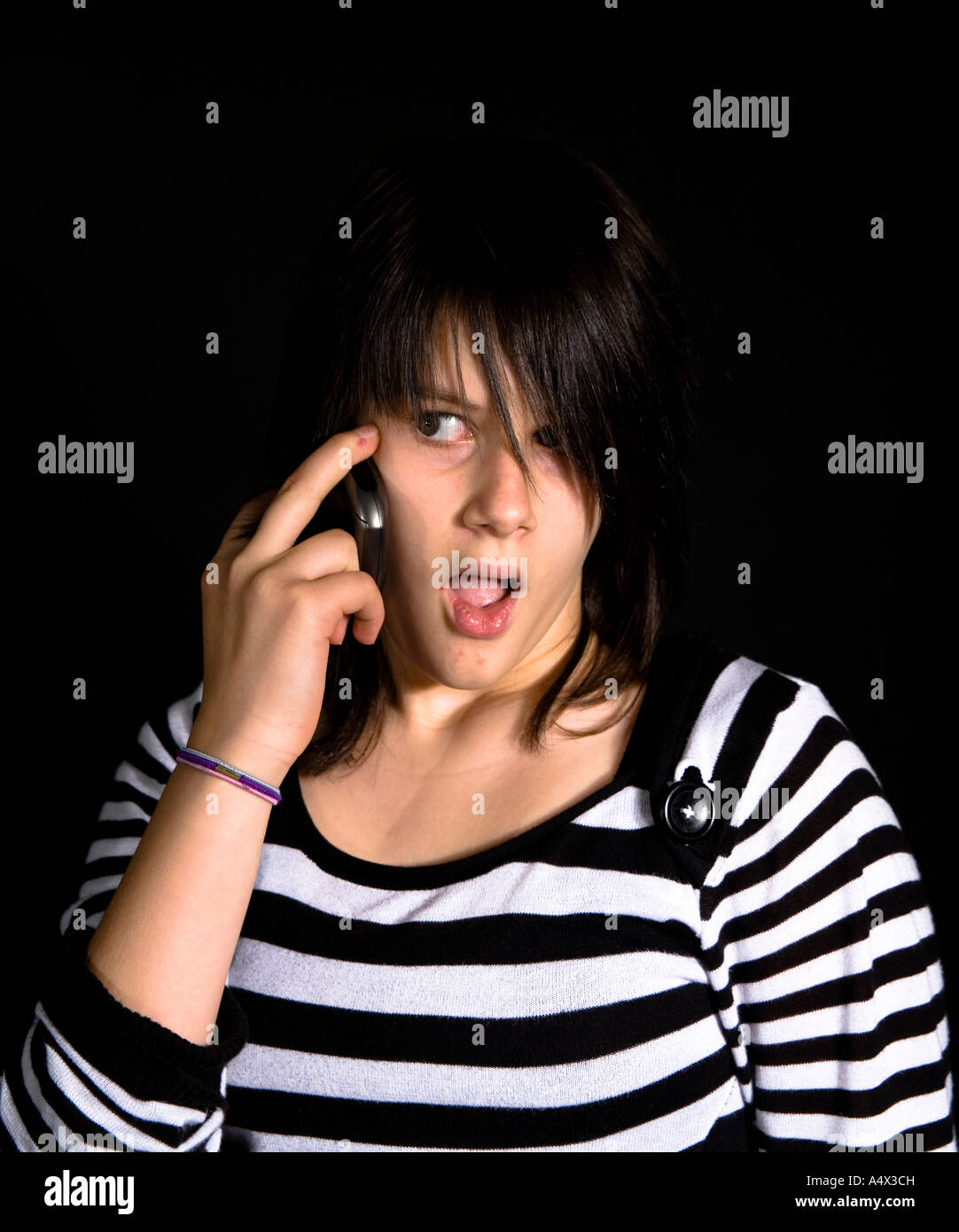 Young girl listens on a mobile phone to gossip Stock Photo - Alamy