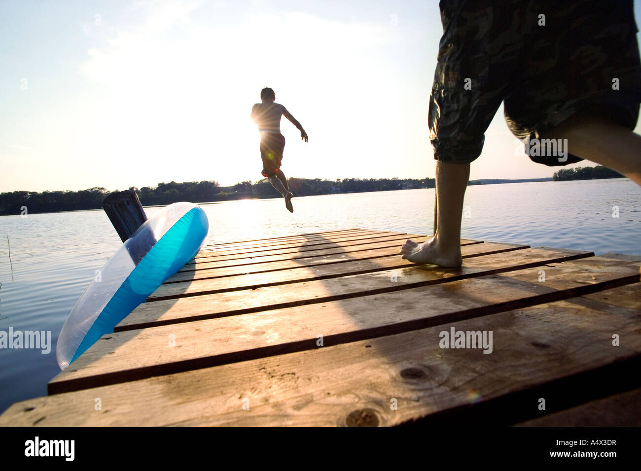 Boy jumping off dock lake hi-res stock photography and images - Alamy