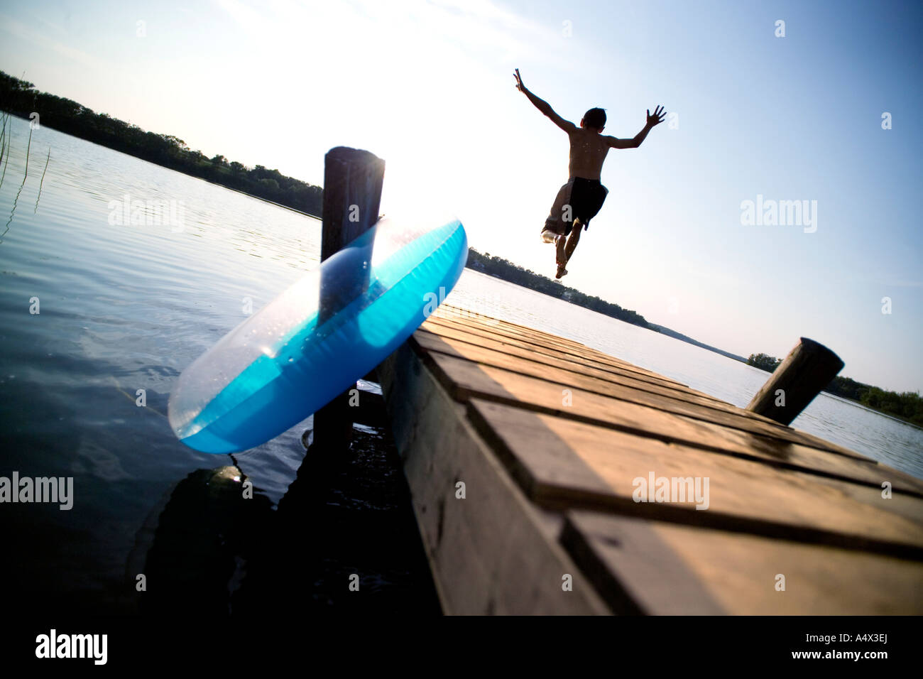 Kids jumping off a dock into a Lake Stock Photo - Alamy