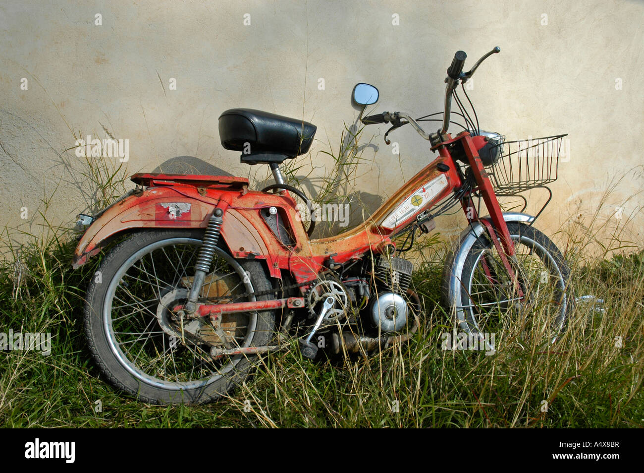 Old red motorcycle leaning against a house, Spain Stock Photo - Alamy