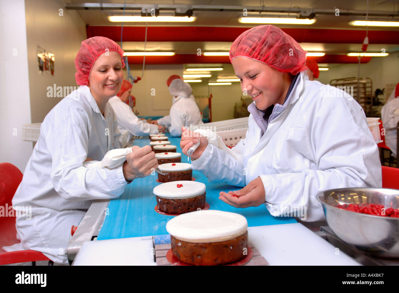 PRODUCTION LINE WORKERS ADDING THE FINISHING TOUCHES TO CHRISTMAS CAKES ...