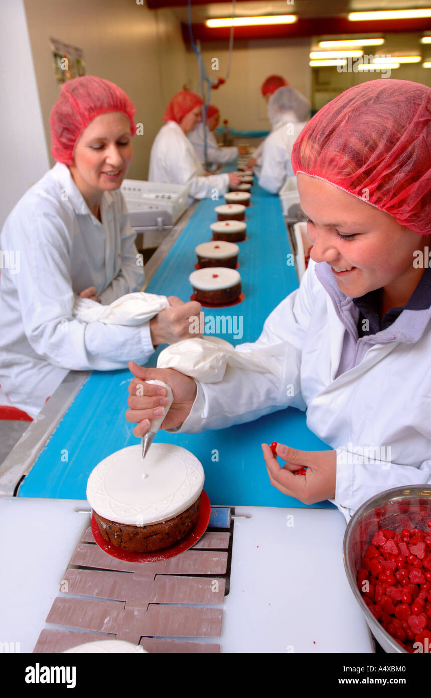PRODUCTION LINE WORKERS ADDING THE FINISHING TOUCHES TO CHRISTMAS CAKES ...