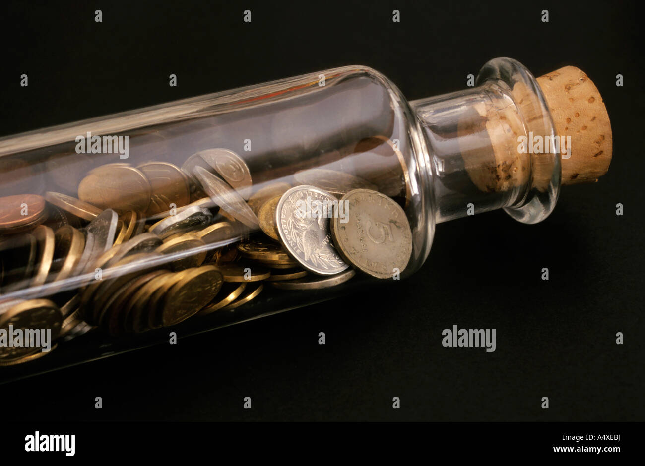 Bottle full of coins lying on its side Stock Photo - Alamy