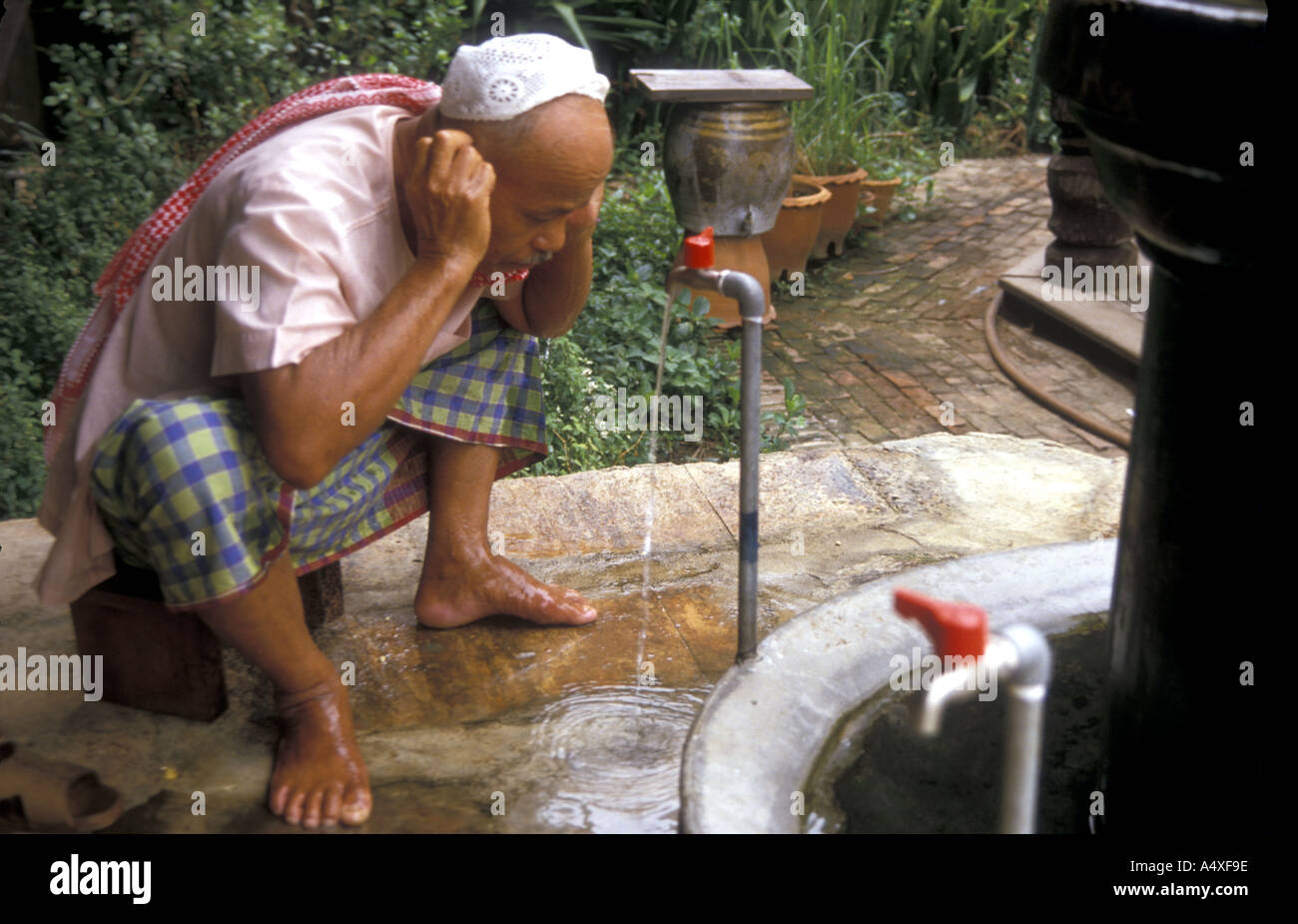 A Muslim man performing wudu before prayers, Malaysia Stock Photo - Alamy